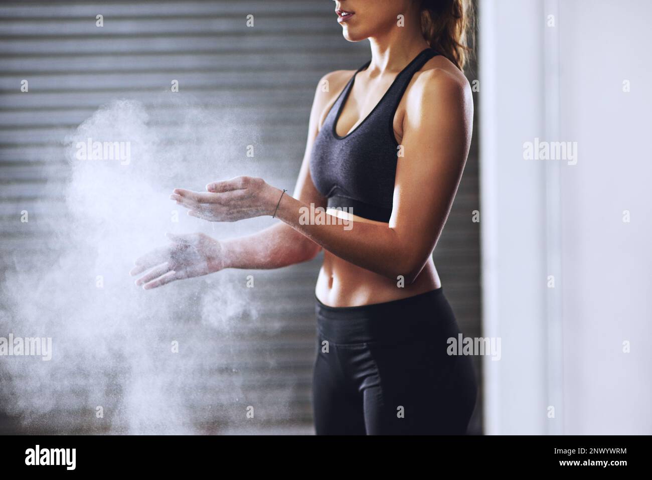 The secret is dedication. a sporty young woman dusting her hands with ...