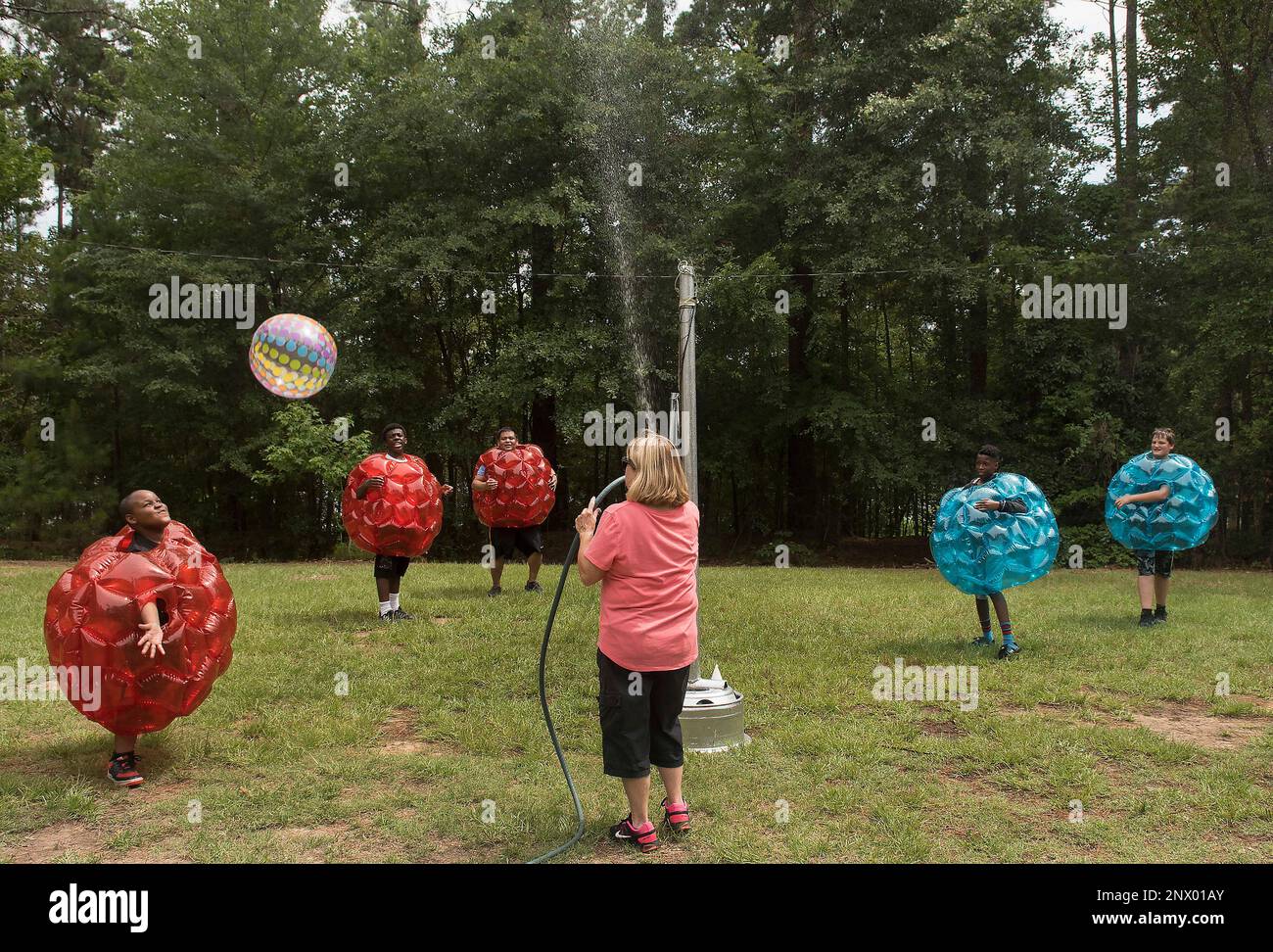 Marilyn Craig sprays water from a hose to cool down campers as they ...