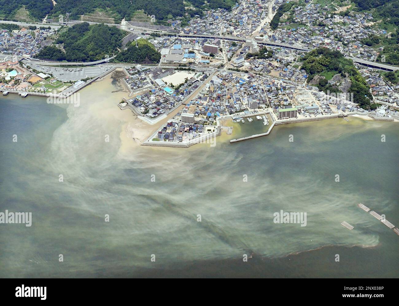 An aerial photo shows muddy water flowing out of river in Kure City ...
