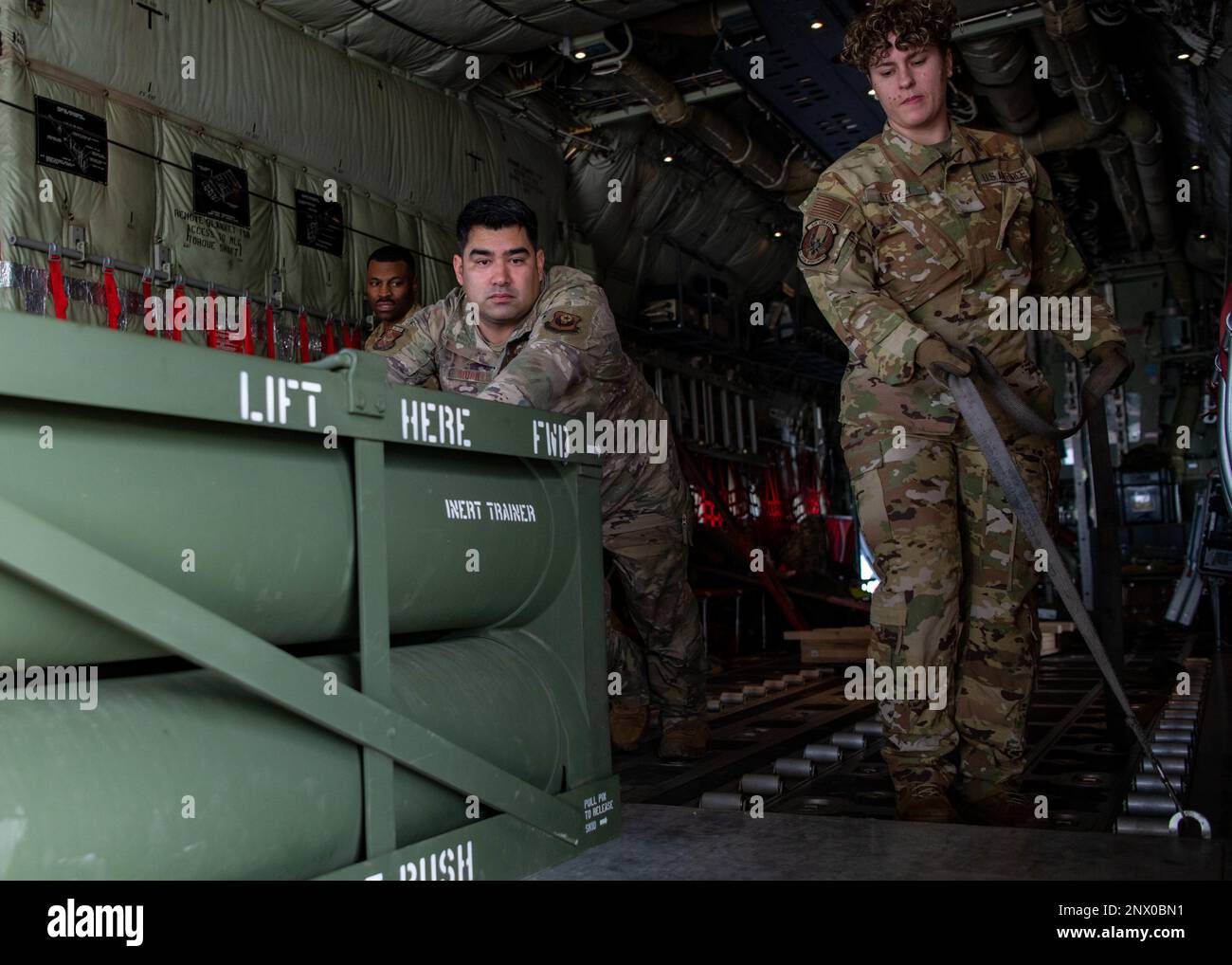 Loadmasters assigned to the 1st Special Operations Squadron push an ...
