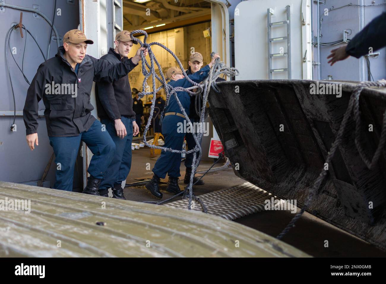 Sailors move a lifeboat on the fantail as the Nimitz-class aircraft ...