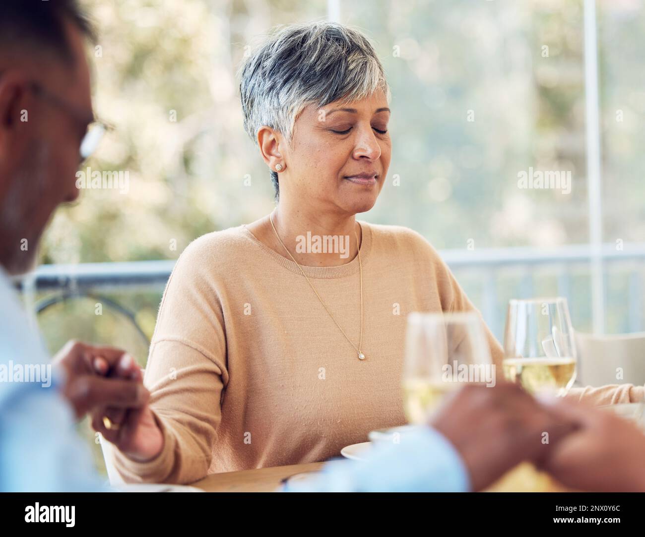 Praying, grace and mature woman and family praise God before dinner or ...