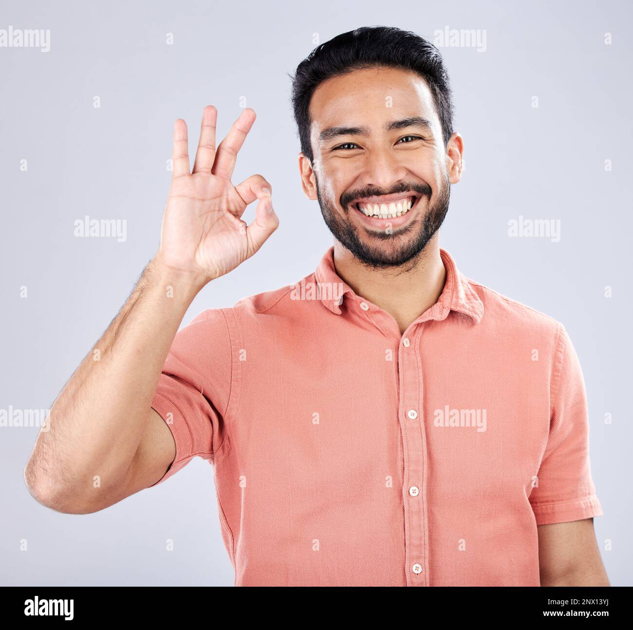 Portrait, hand sign and perfect with a man in studio on a gray ...