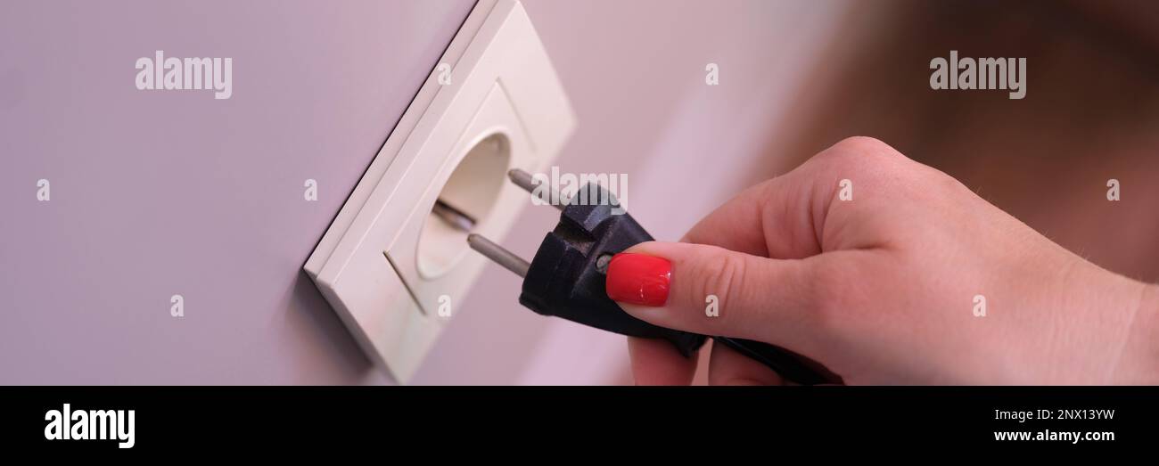 Hand inserts plug into socket closeup. Use of promising energy in home ...