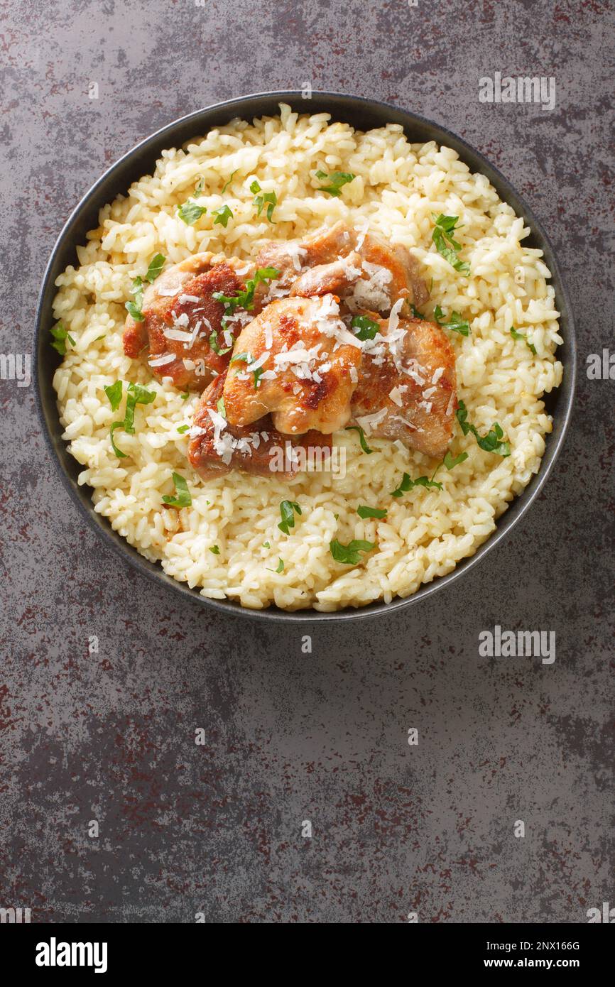 Creamy parmesan risotto served with fried chicken close-up in a plate ...