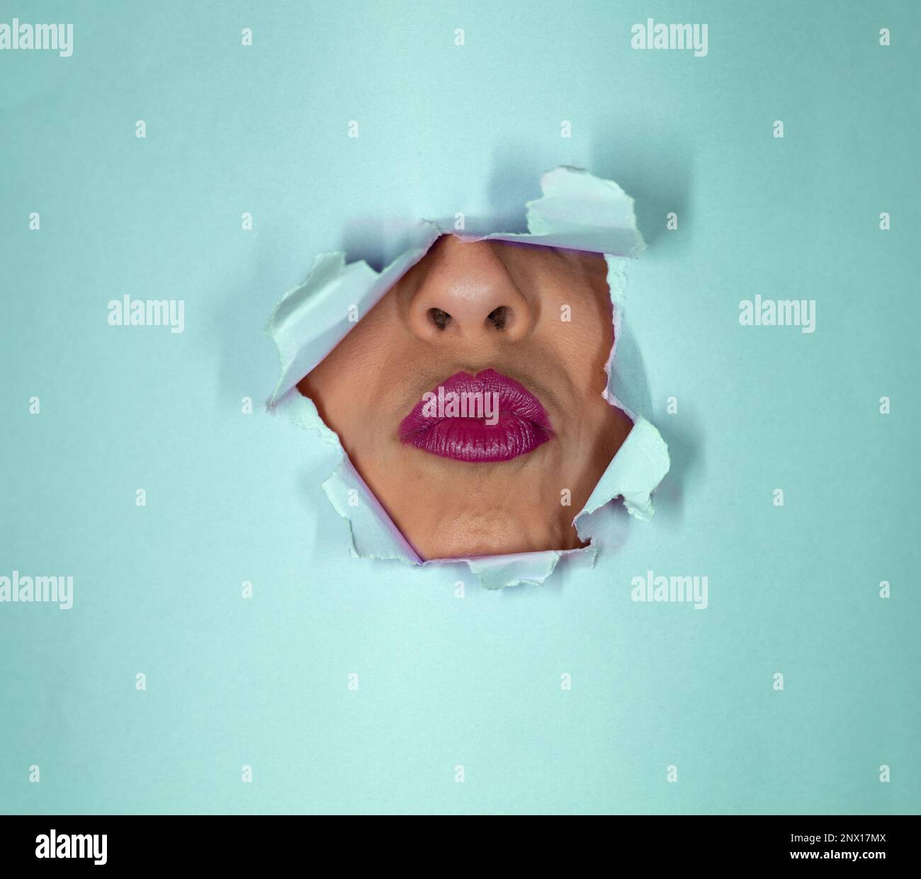 lips and face of a woman protruding through a turquoise cardboard Stock ...