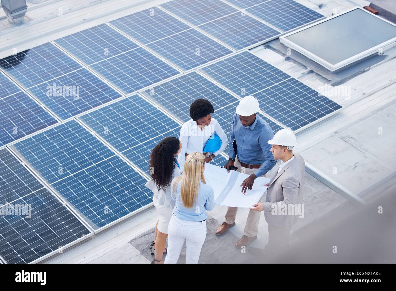 Solar energy, teamwork or engineering designers with blueprint on roof ...