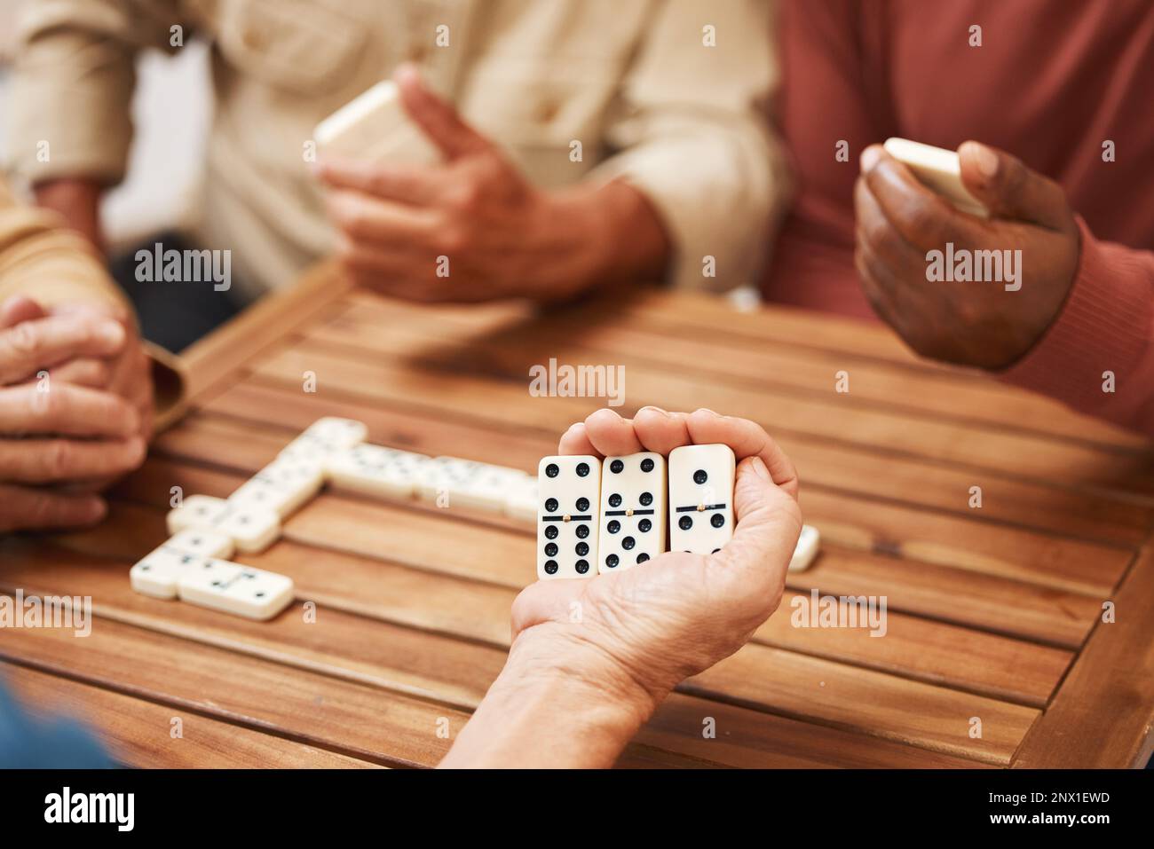 Hands, dominoes and friends in board games on wooden table for fun ...