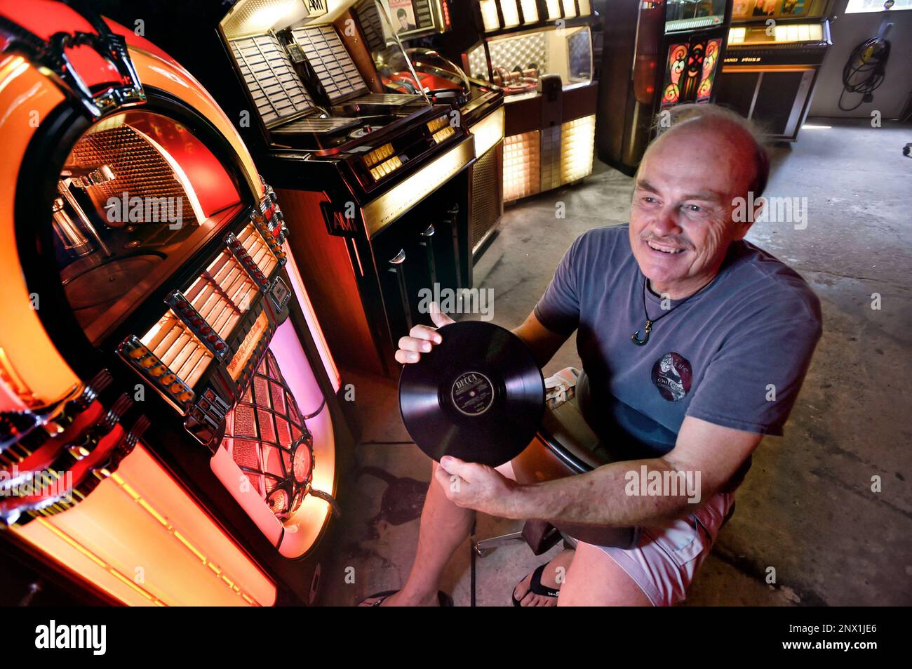 Ross Williams sits among some of the antique juke boxes that he has ...