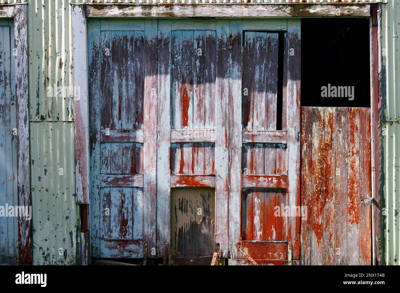 A timber and corrugated iron building has fallen into disrepair. Its ...