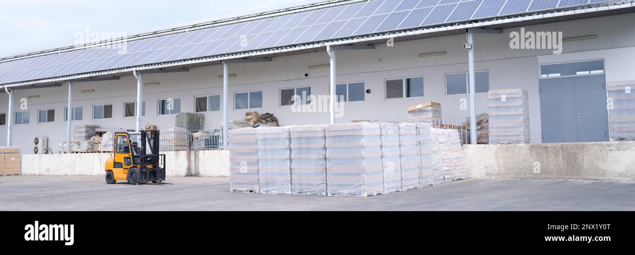Forklift and pallets with goods in large warehouse outside warehouse ...