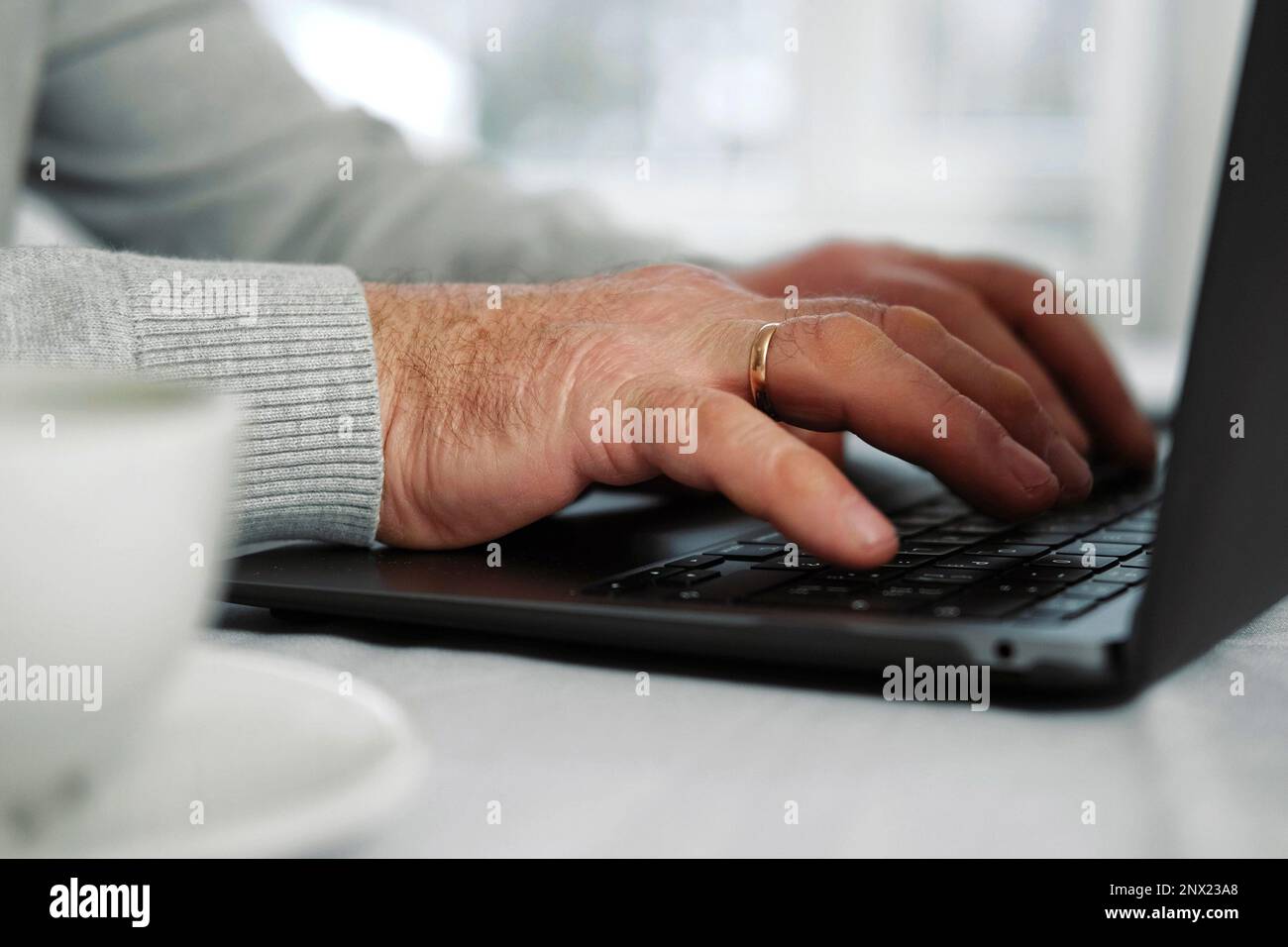 Closeup of senior man hands using laptop. Cropped side view of wrinkled ...