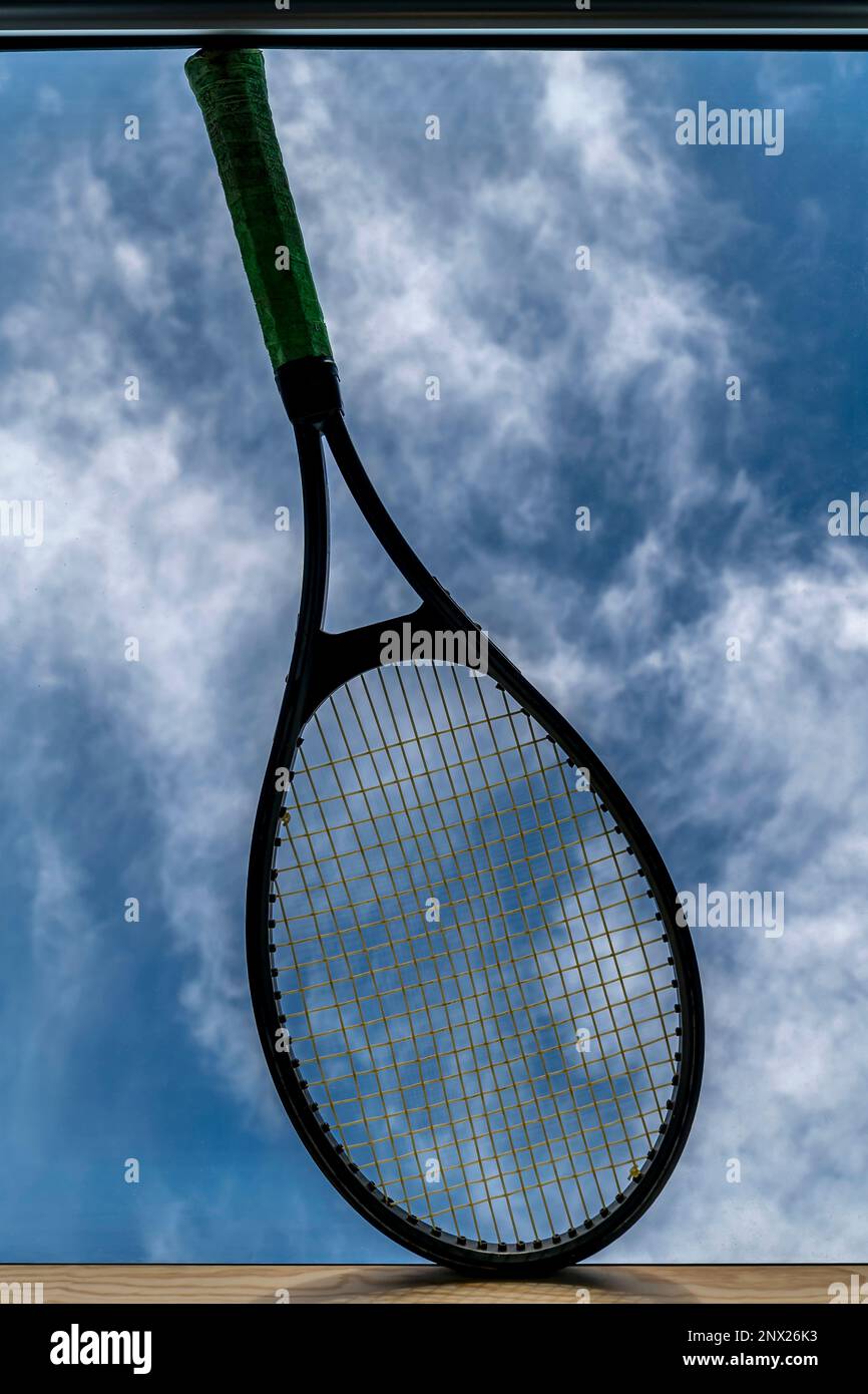 A tennis racket standing against the blue sky with white clouds Stock ...
