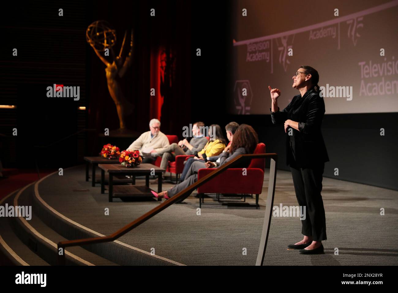 An ASL sign language interpreter works on stage while Television ...