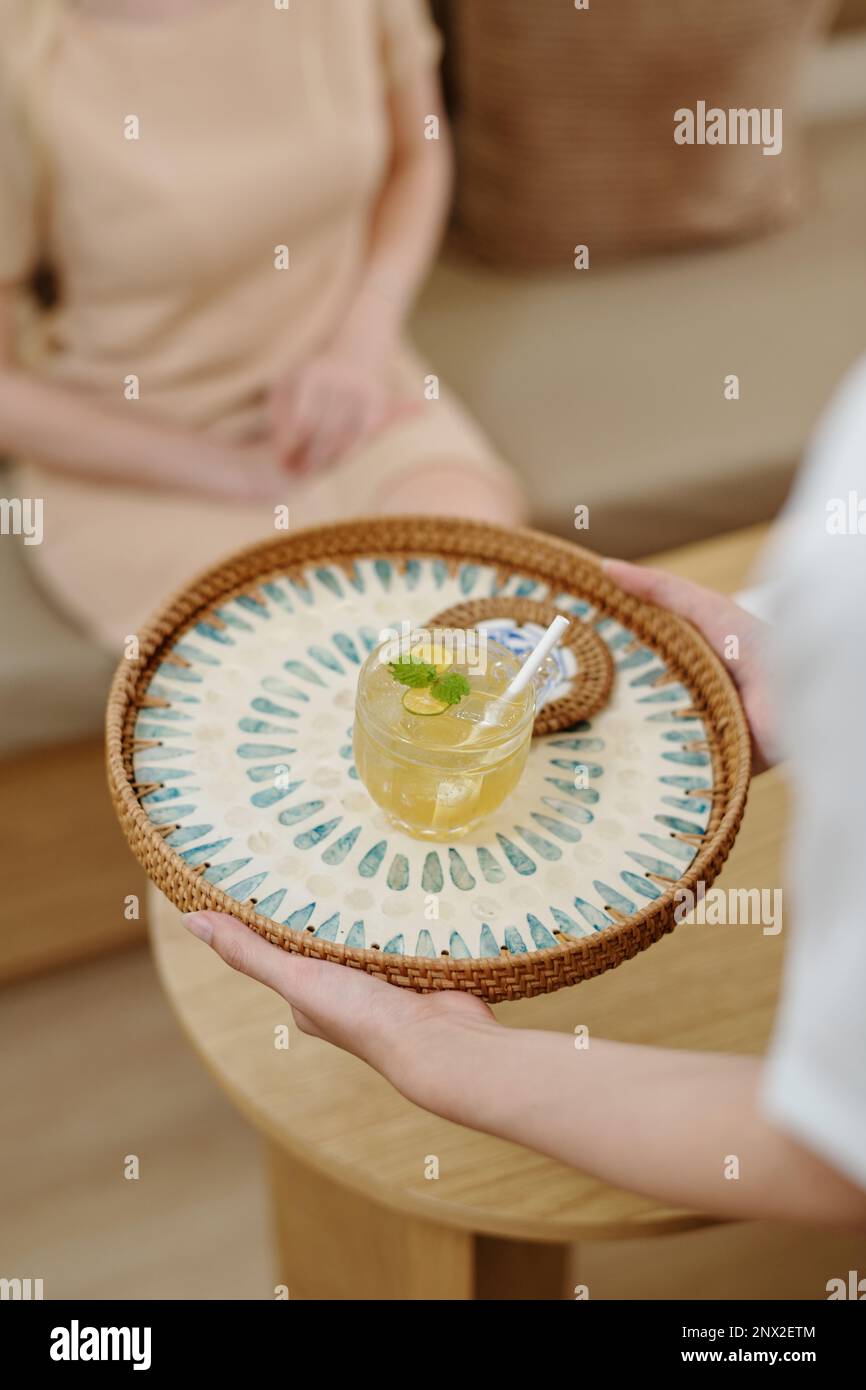 Beauty salon receptionist bringing tray with soft drink to client Stock ...