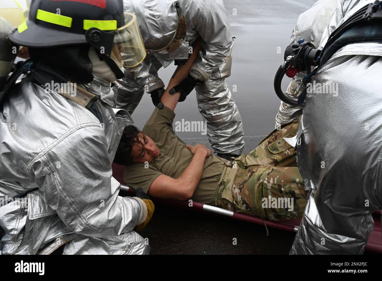 Palau International Fire fighters place a U.S. Air Force member of the ...