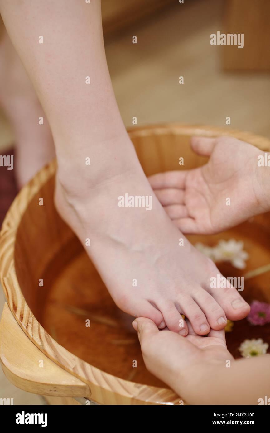Spa salon worker making foot bath for female client Stock Photo - Alamy