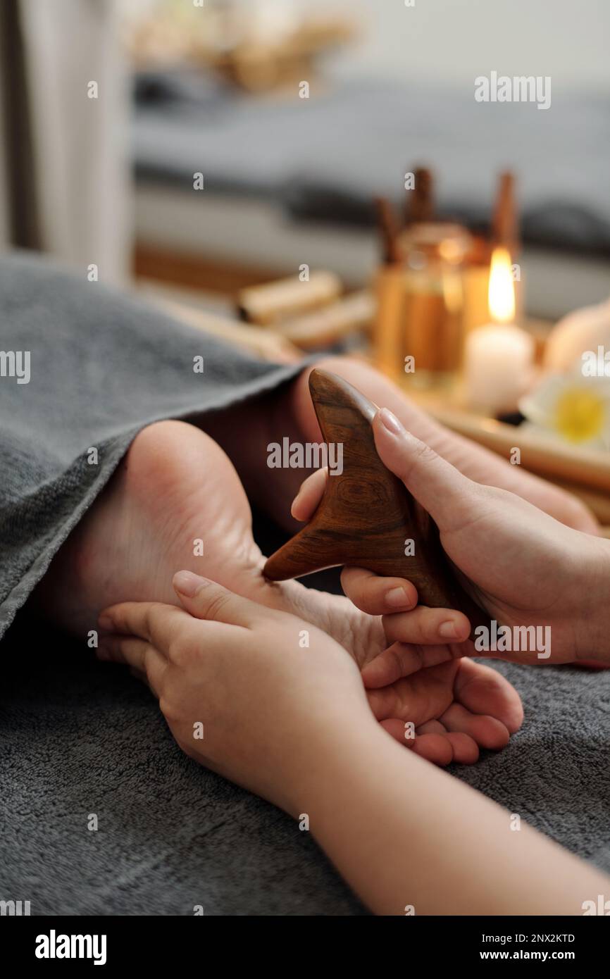 Feet of woman getting reflexology feet massage with wooden sticks Stock ...