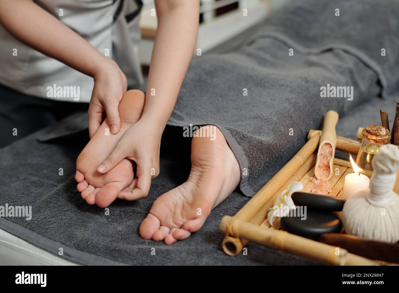 Therapist giving deep tissue feet massage to woman to relieve anxiety ...