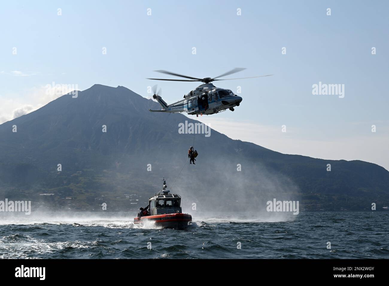 A Japan Coast Guard Mobile Rescue Technician hoists a simulated swimmer ...