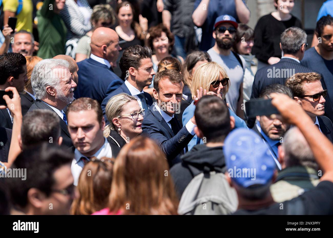 French President Emmanuel Macron, center, waves to onlookers during a ...