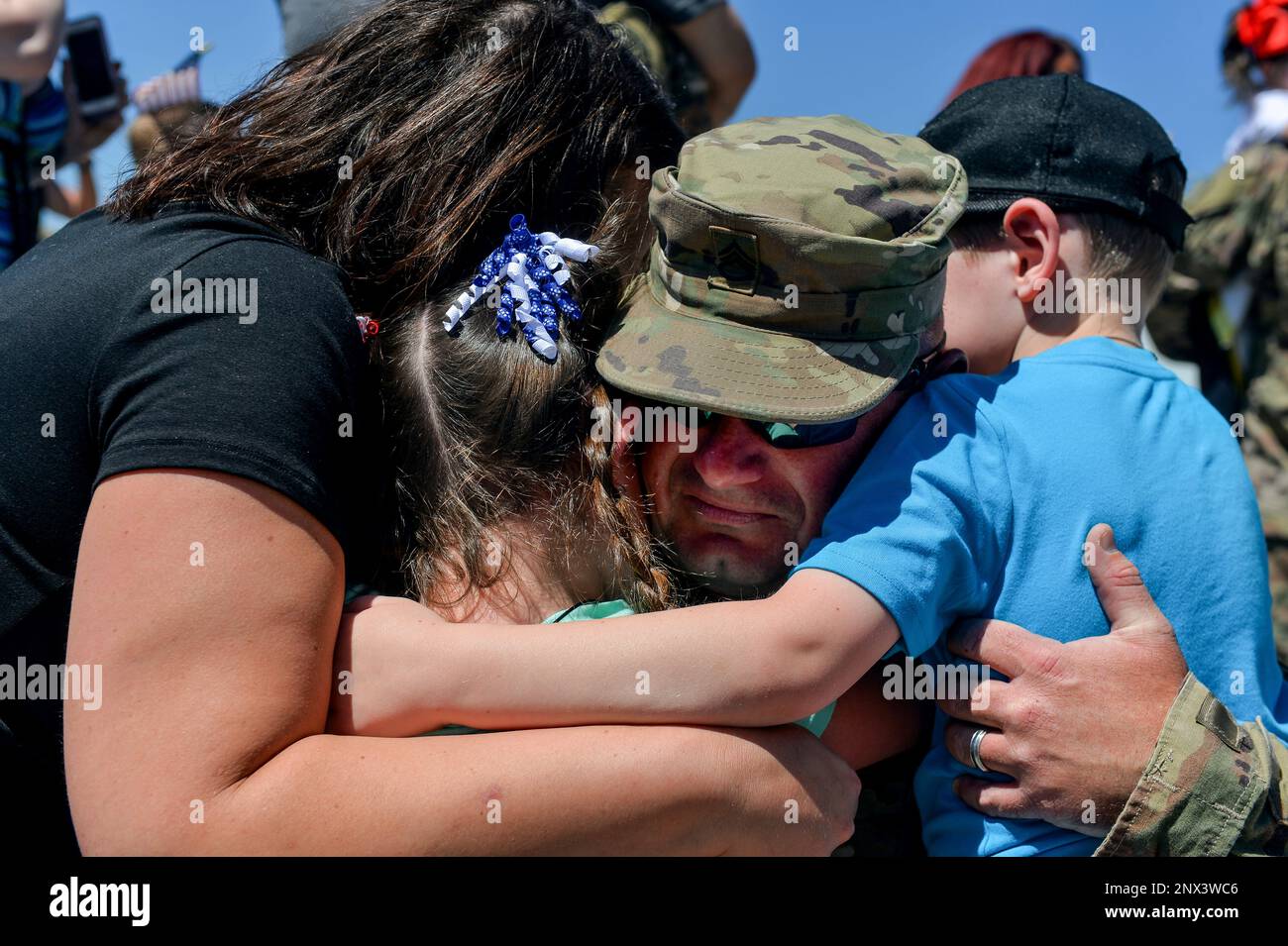 Staff Sgt. Travis Lopeman hugs his children, Titus, 5, and Annalese, 8 ...