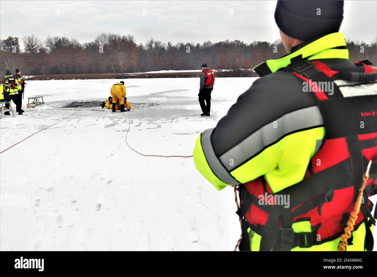 Firefighters wearing cold-water immersion protective suits hold surface ...