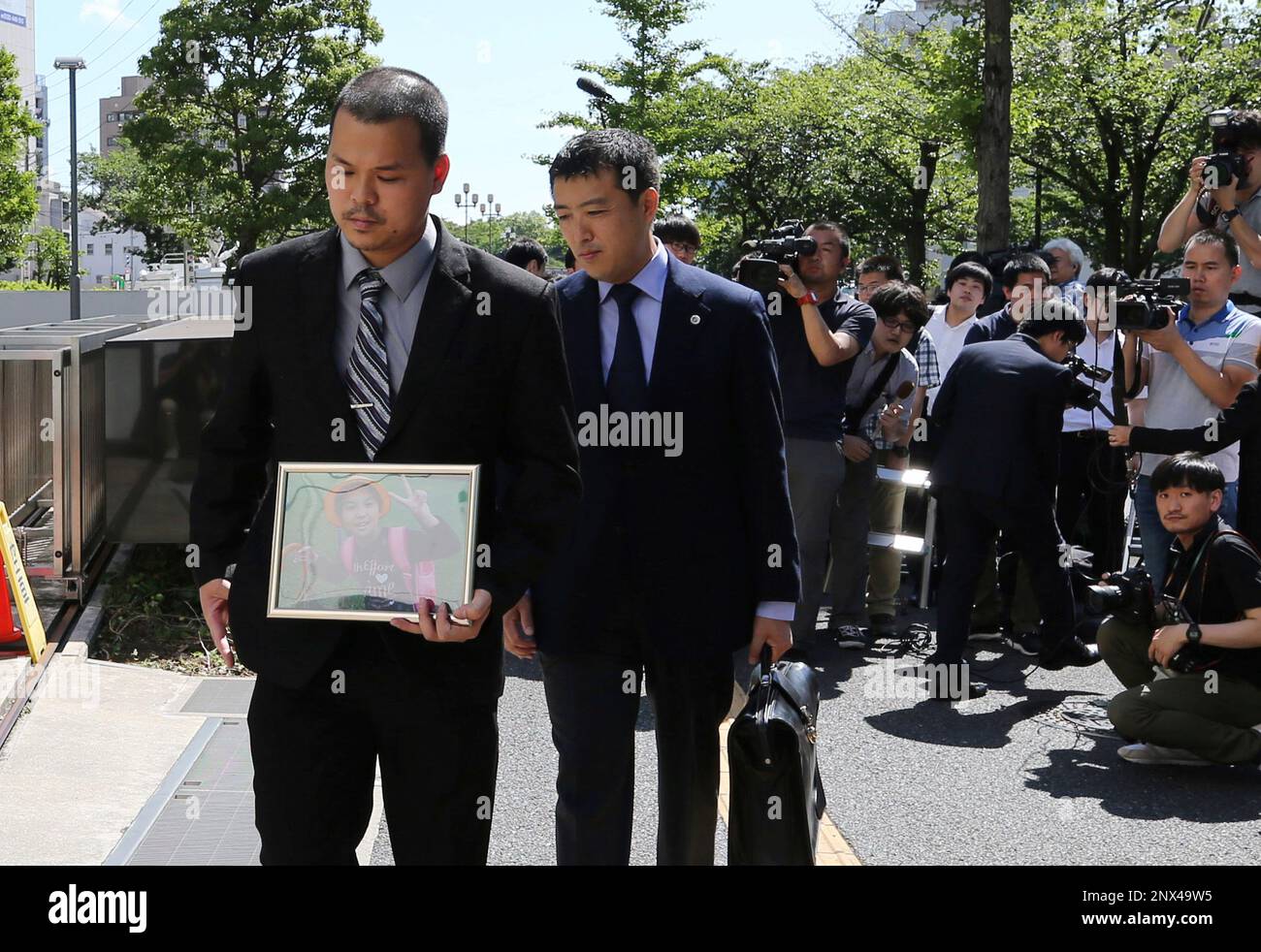 Vietnamese Le Anh Hao(L) holding his daughter's photo heads for Chiba ...