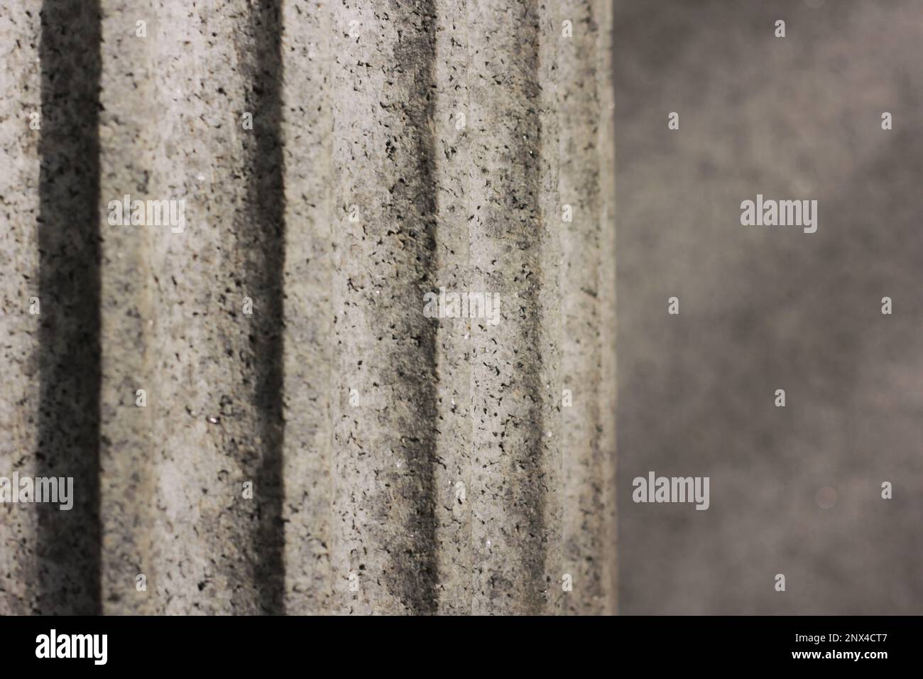 A minimalist closeup view of a fluted column carved in natural stone ...