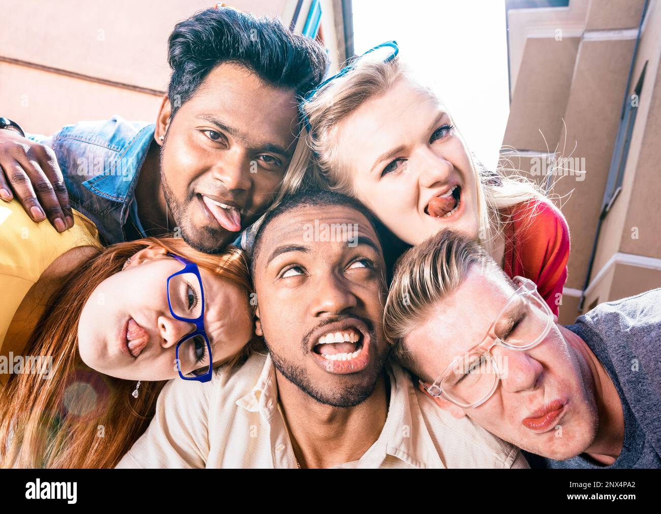 Multiracial millenial friends taking selfie sticking out tongue with ...