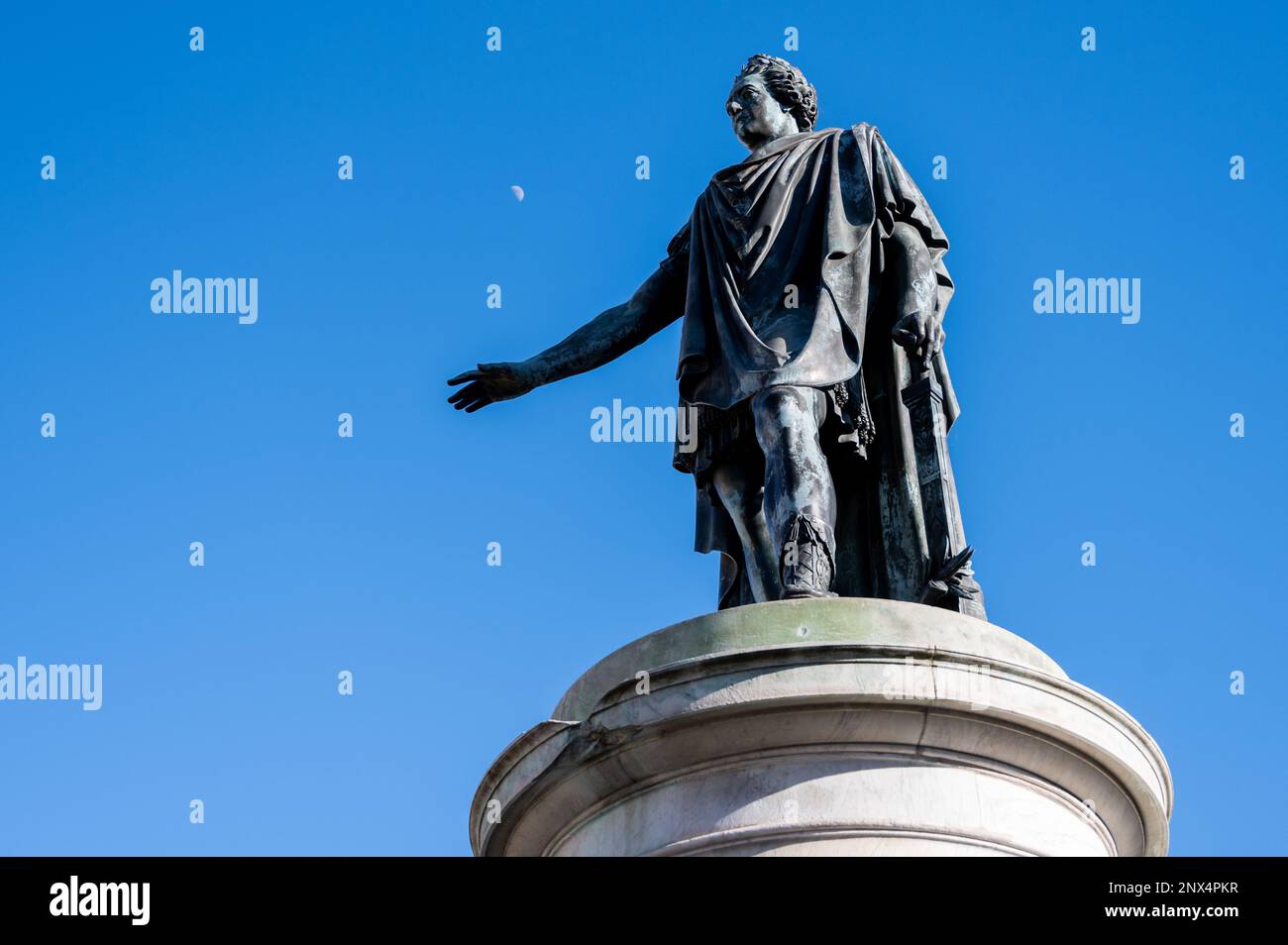 The statue of Louis XV set against a blue sky and the moon in the Place ...