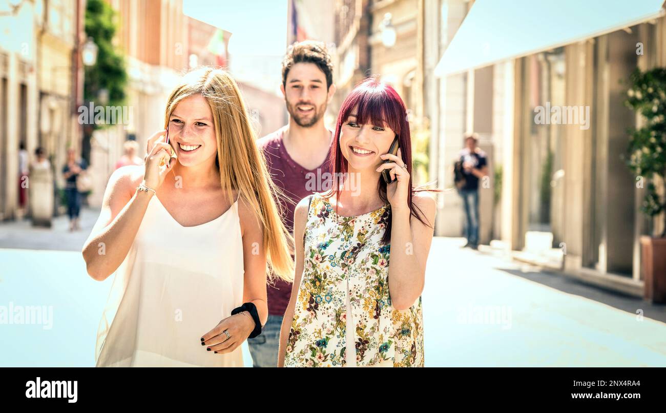 Young man following pretty women while having fun together on city ...