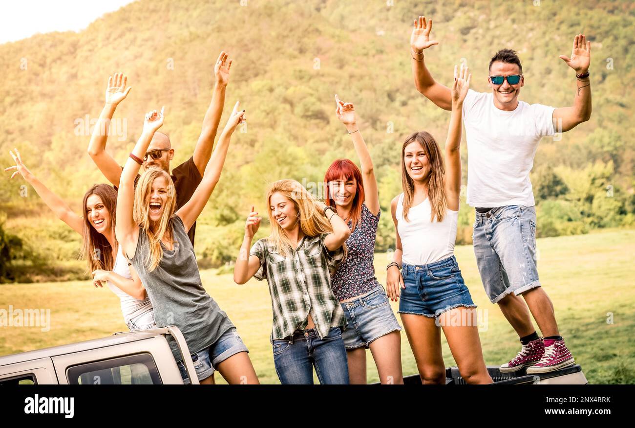 Group of happy friends having fun at countryside party ride on pick up ...
