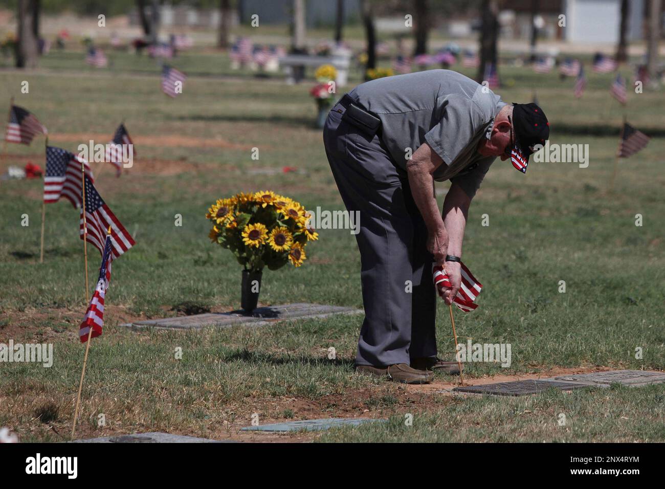 Bob McAlpine places an American Flag at his brothers grave Monday, May ...