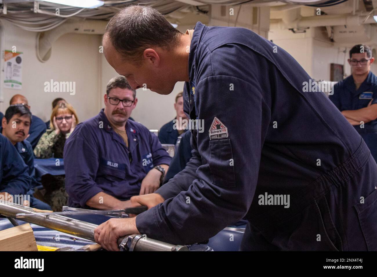 SINGAPORE (Feb. 23, 2023) – Chief Damage Controlman David Martinez saws ...