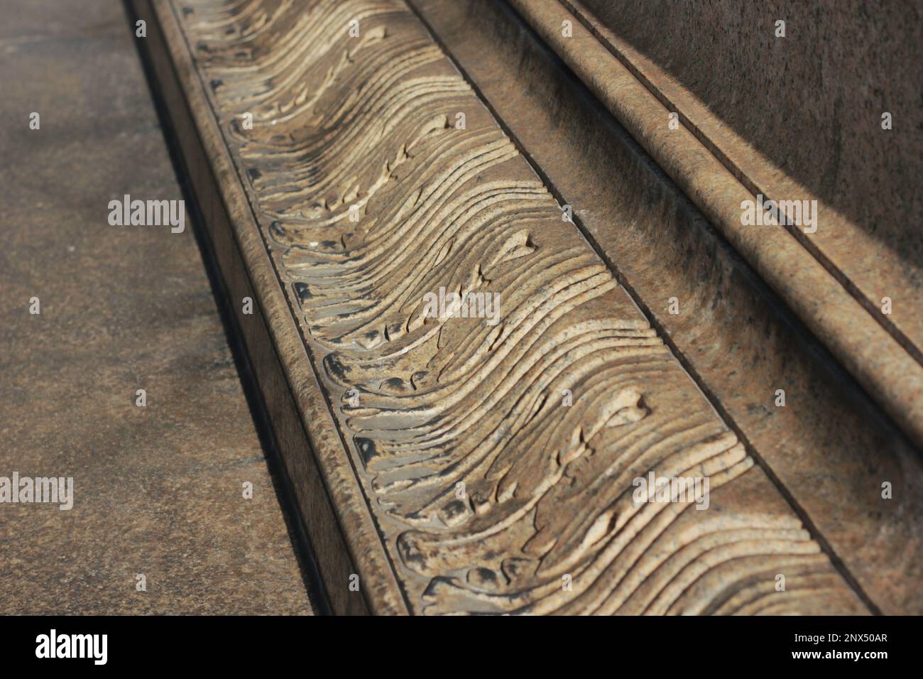 A repeating pattern carved into a natural stone wall Stock Photo - Alamy