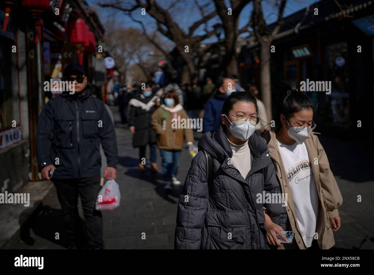People wearing face masks tour a tourist shopping street in Beijing ...