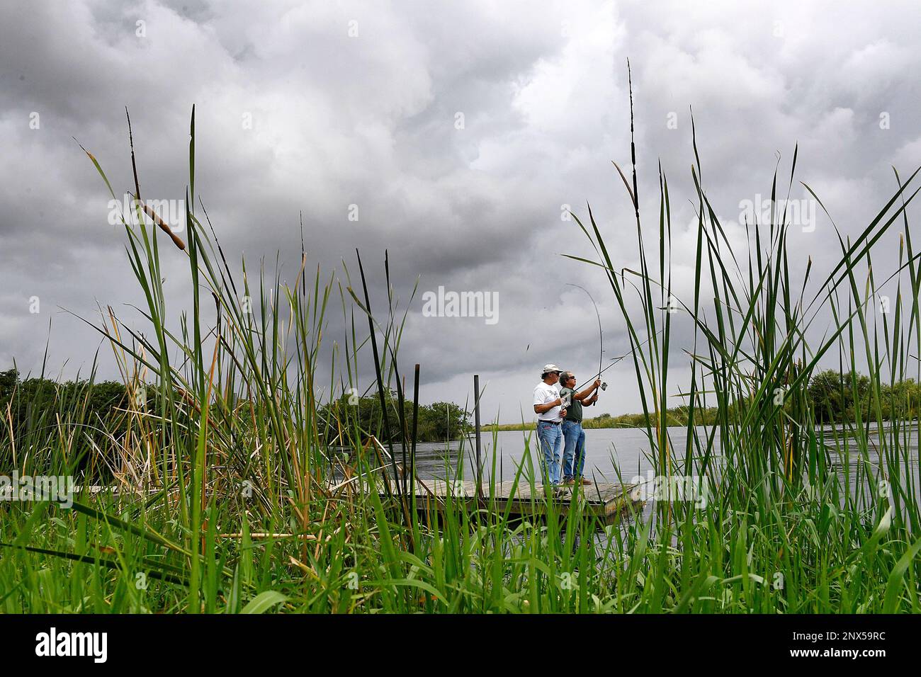 Mario Badia and his brother, Robert Badia, fish on the edge of a boat ...