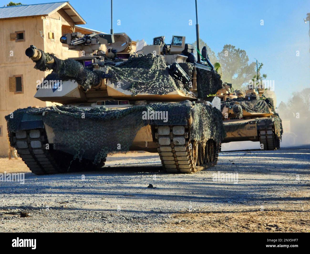 Tanks maneuver through a town in the box at the Joint Readiness ...