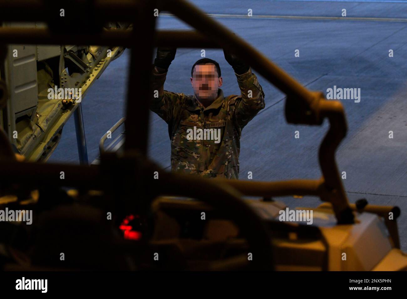 A U.S. Air Force loadmaster with the 67th Special Operations Squadron, guides a fellow ...