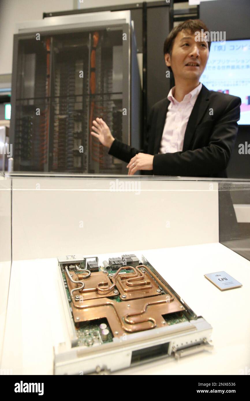 A man shows the CPU(Front R), the system board(Front L) and the rack ...