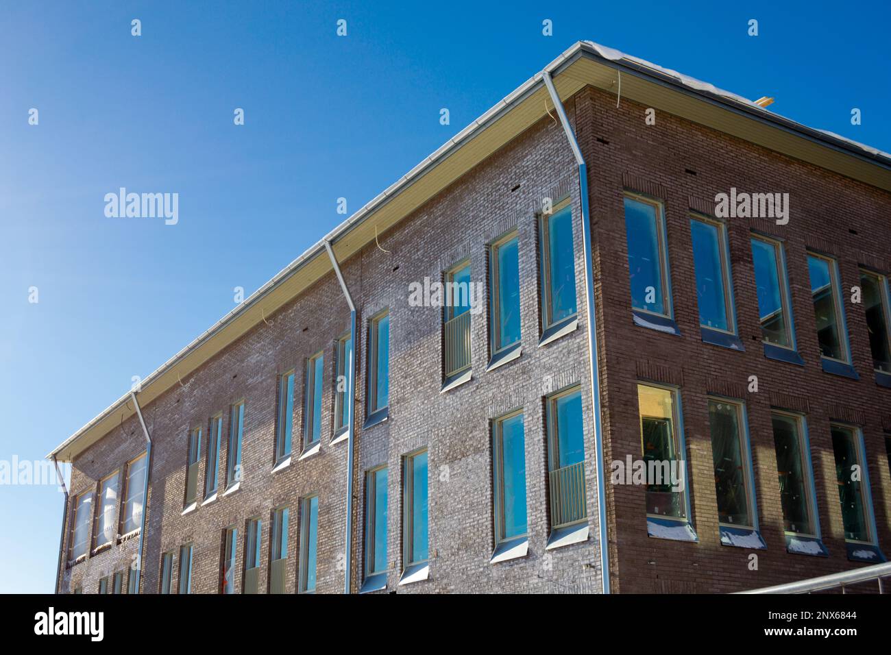 Light gray brick building. A clear blue cloudless sky in the background ...