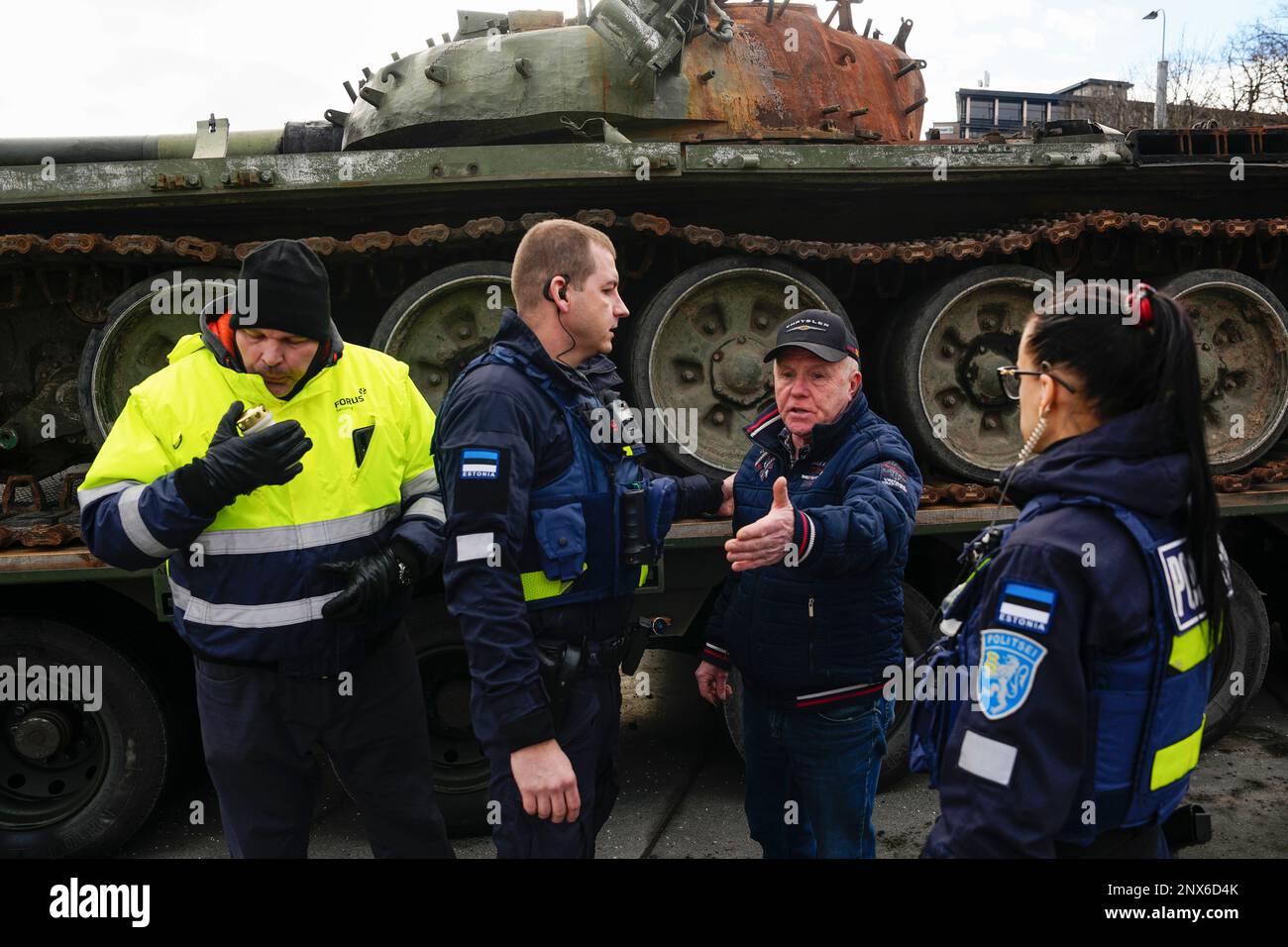 A security guard, left, blows out a candle as police officers talk with ...