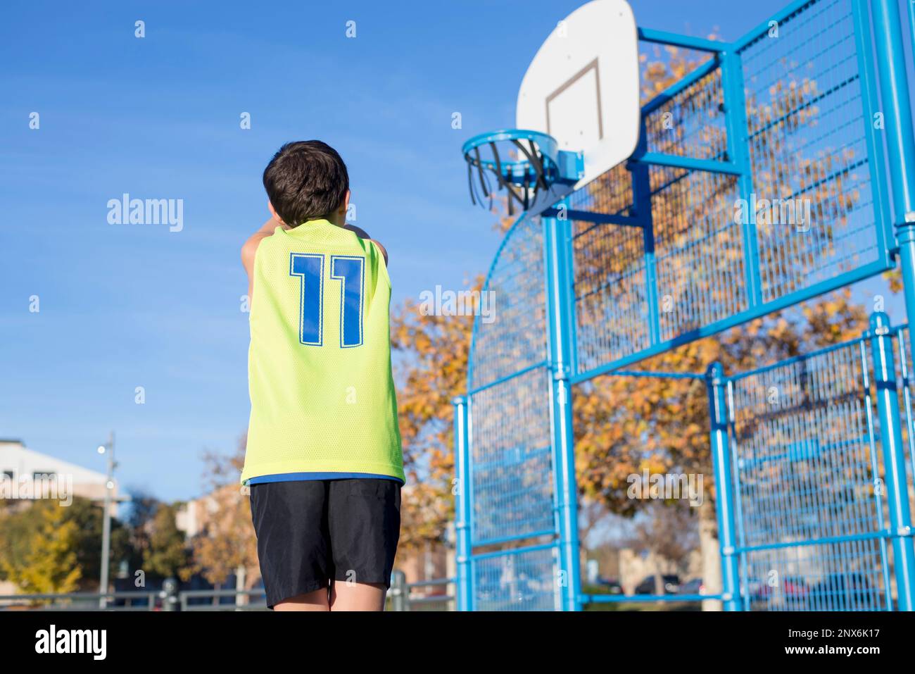 Low angle of a child playing basketball on an urban basketball court ...