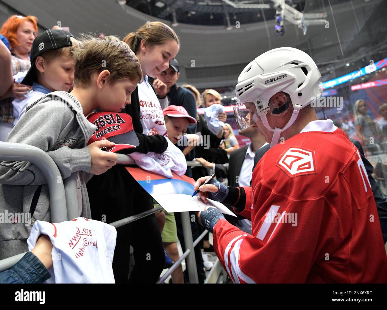 Russian President Vladimir Putin, right, gives autographs after a match ...