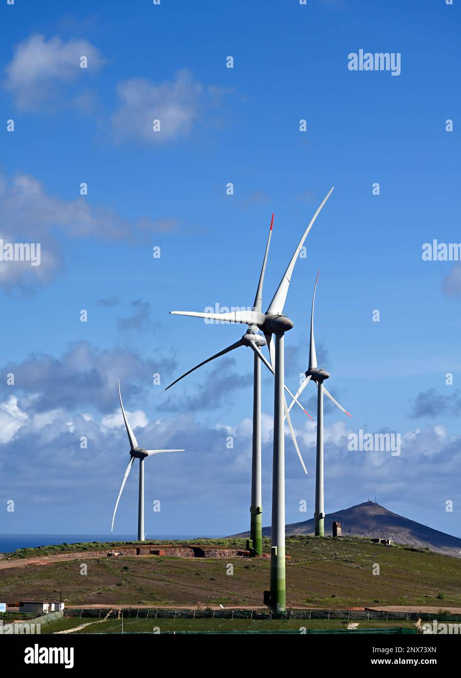 Field with multiple wind turbines and hill in distance Stock Photo - Alamy