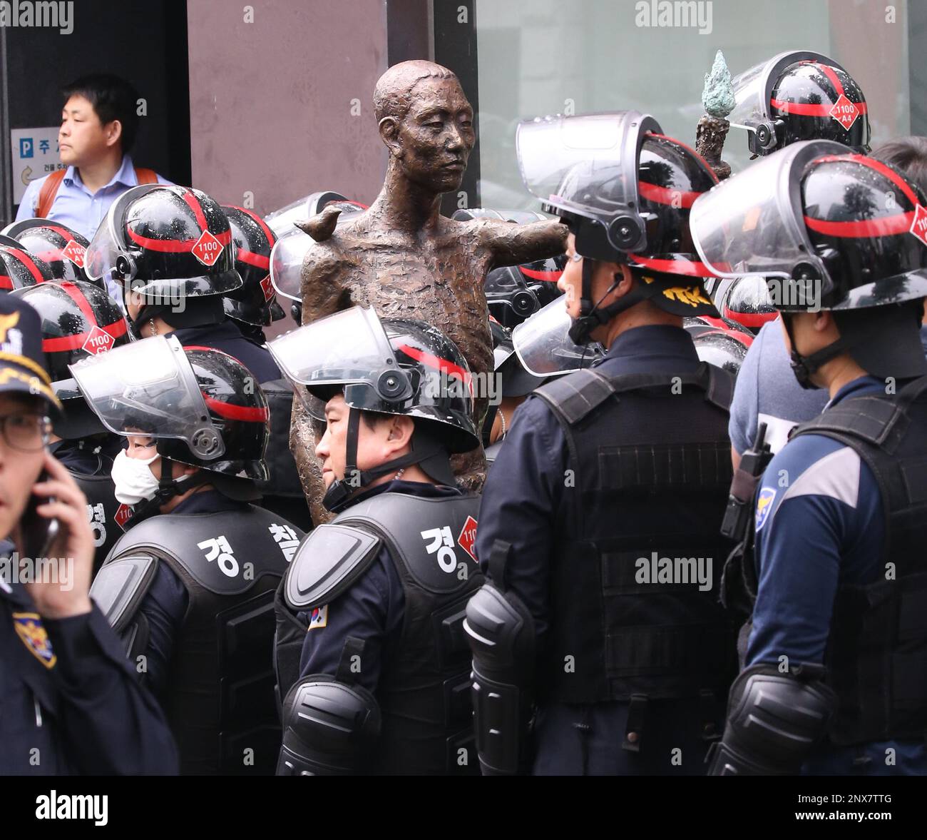 The riot police stand to guard near a statue of a girl symbolizing the ...