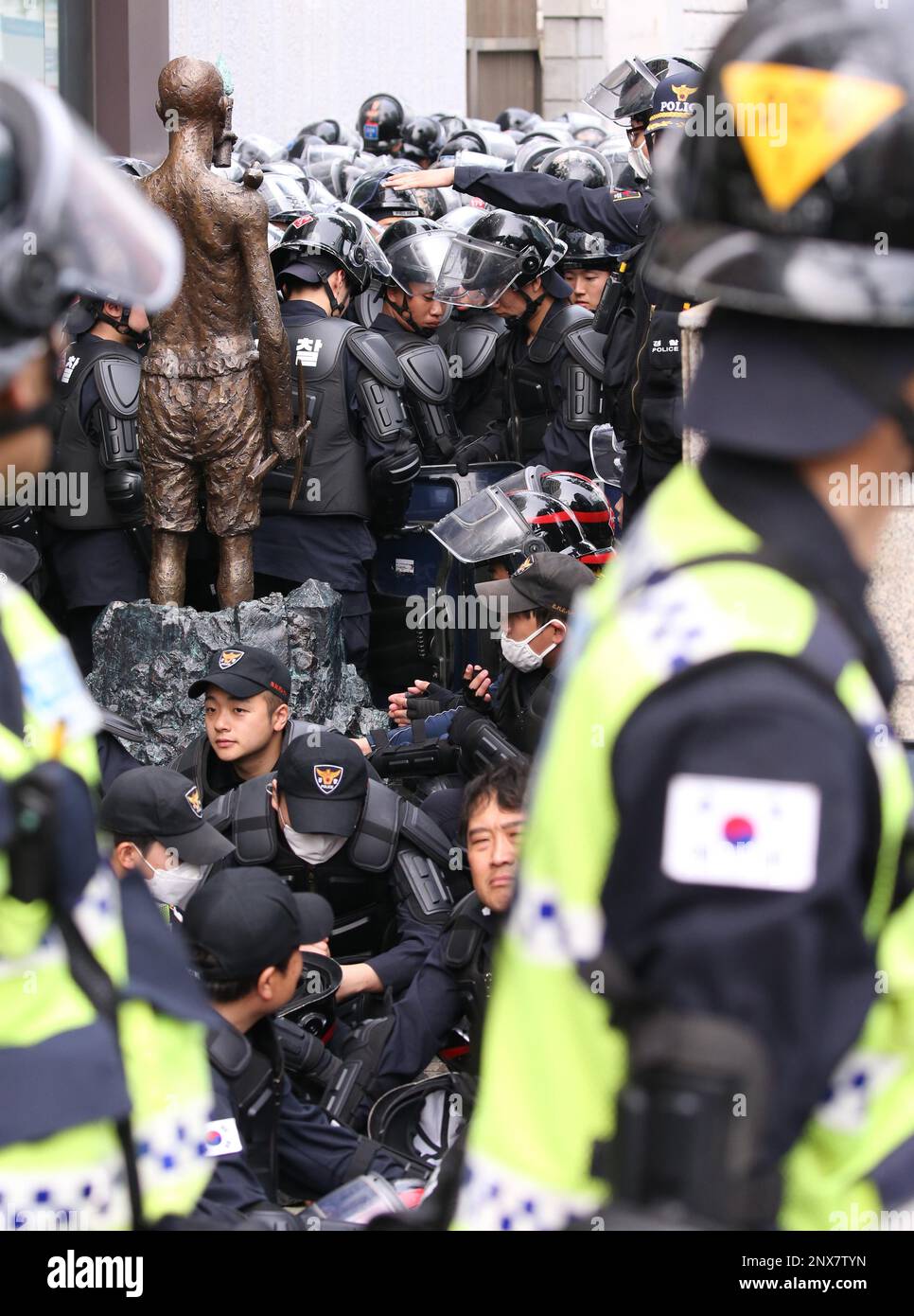 The riot police stand to guard near a statue of a girl symbolizing the ...