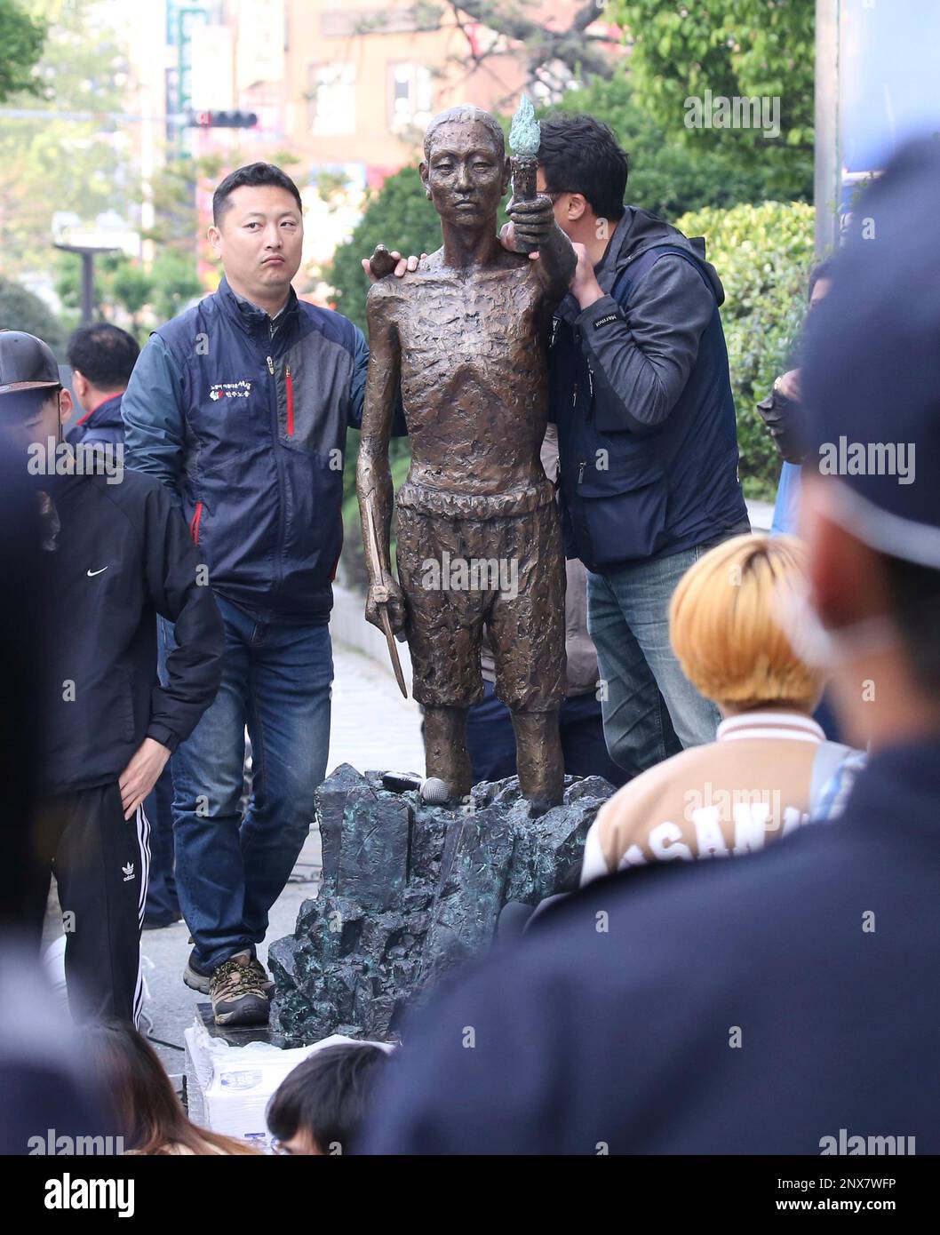 Members of civic activist aim to a statue symbolizing forced Korean ...