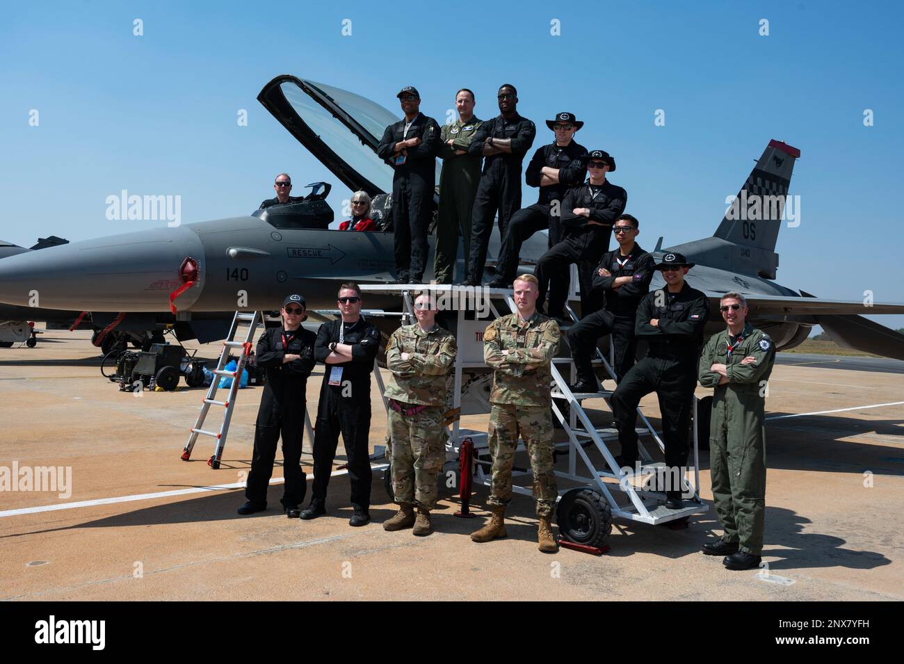 U.S. officials take a group photo with members of the Pacific Air Forces F-16 Demonstration Team ...